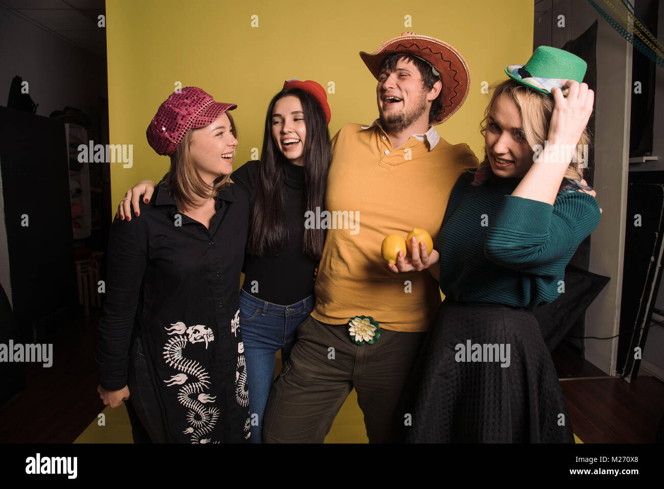 Four young friends standing together . The studio shot Stock Photo - Alamy