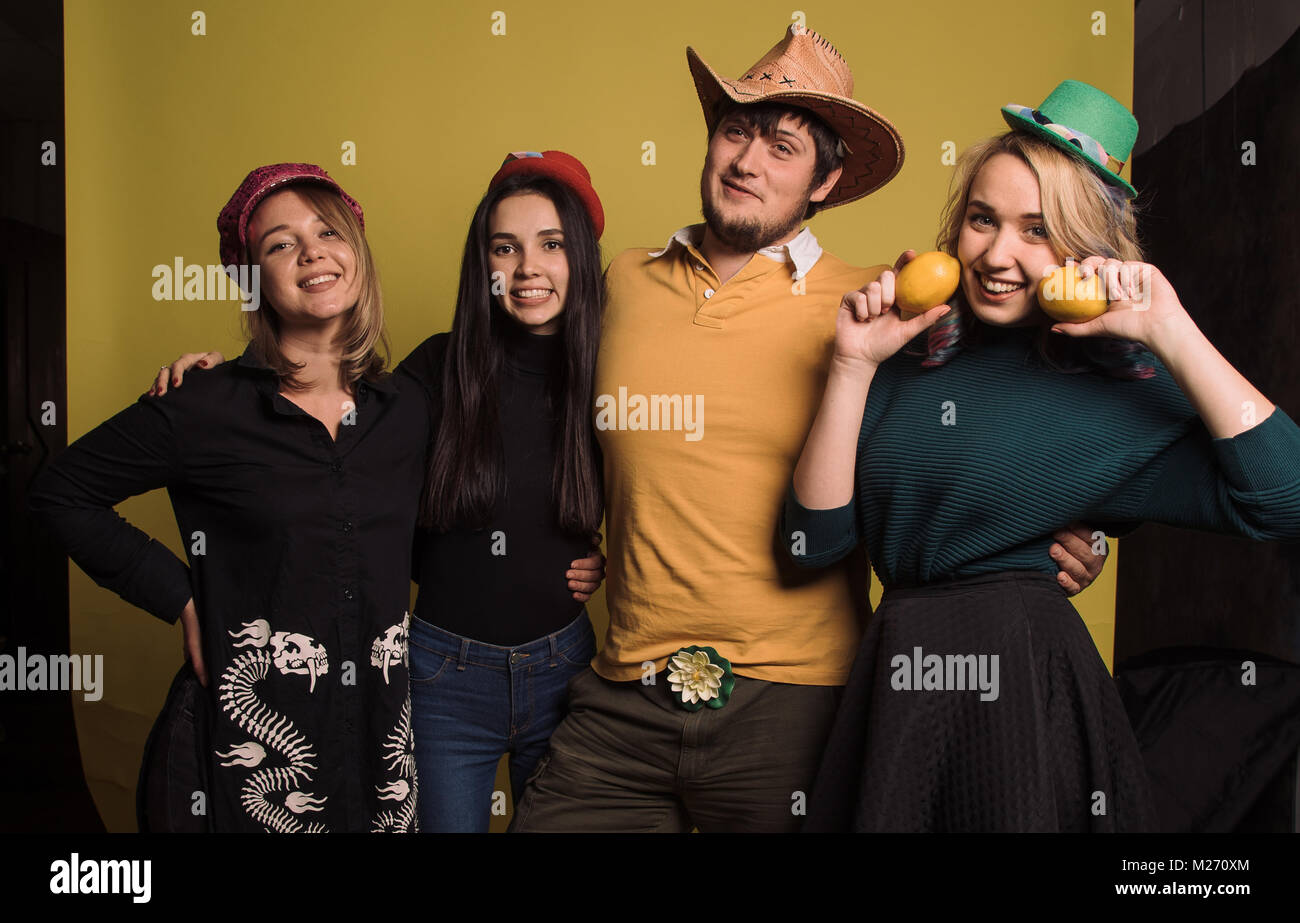 Four young friends standing together . The studio shot Stock Photo - Alamy