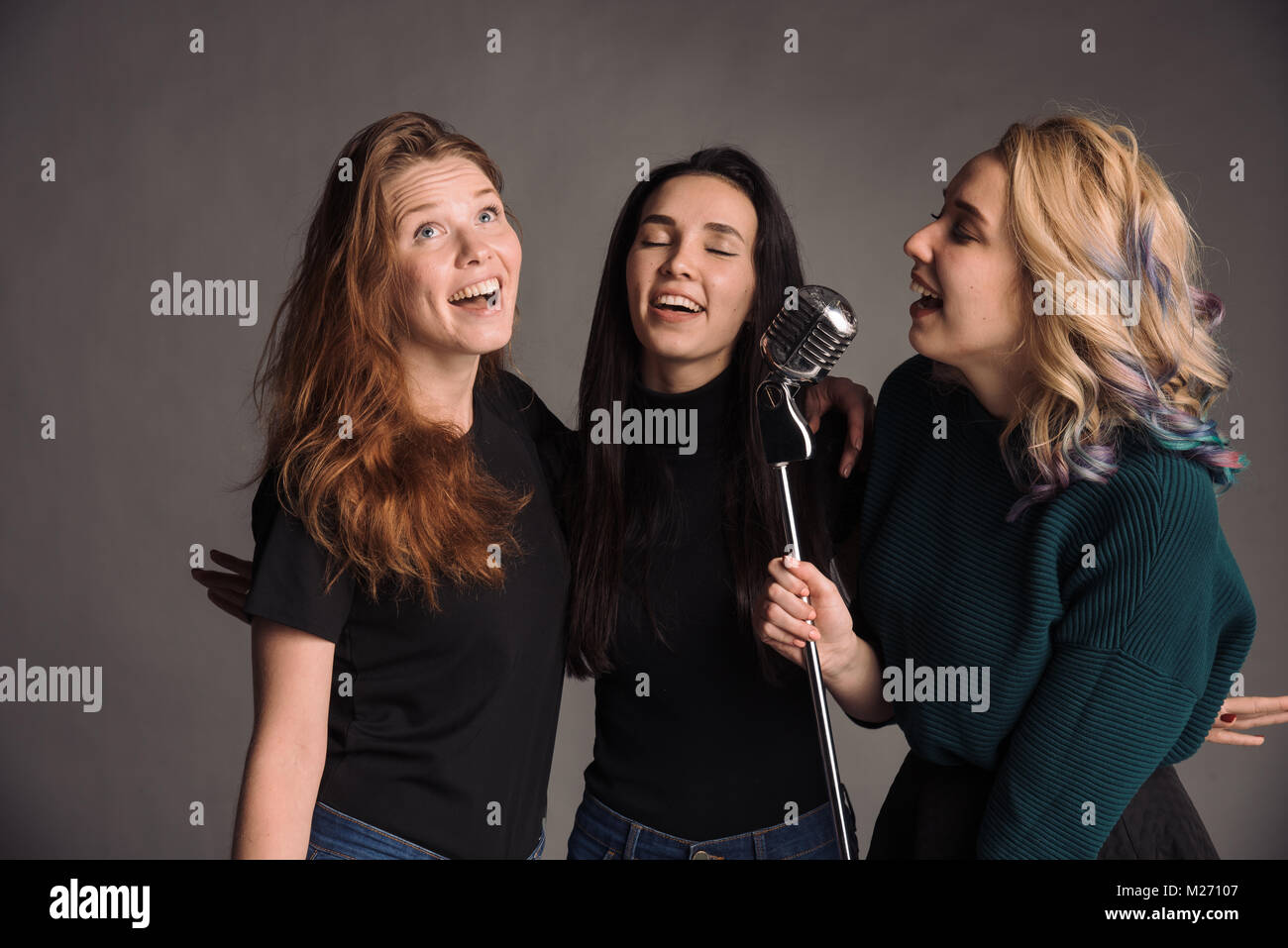 Three young friends standing together. The studio shot Stock Photo - Alamy