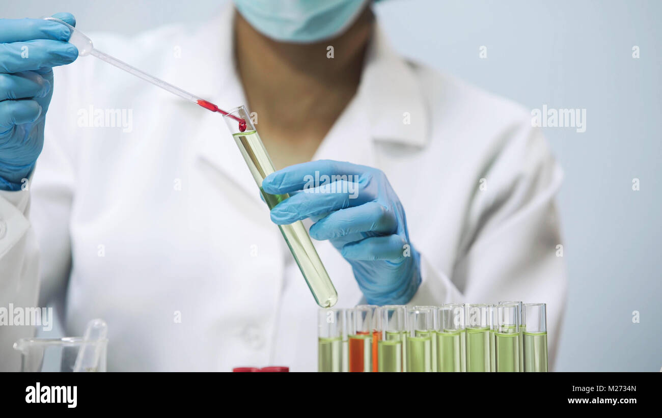 Scientist dropping liquid test tubes hi-res stock photography and ...