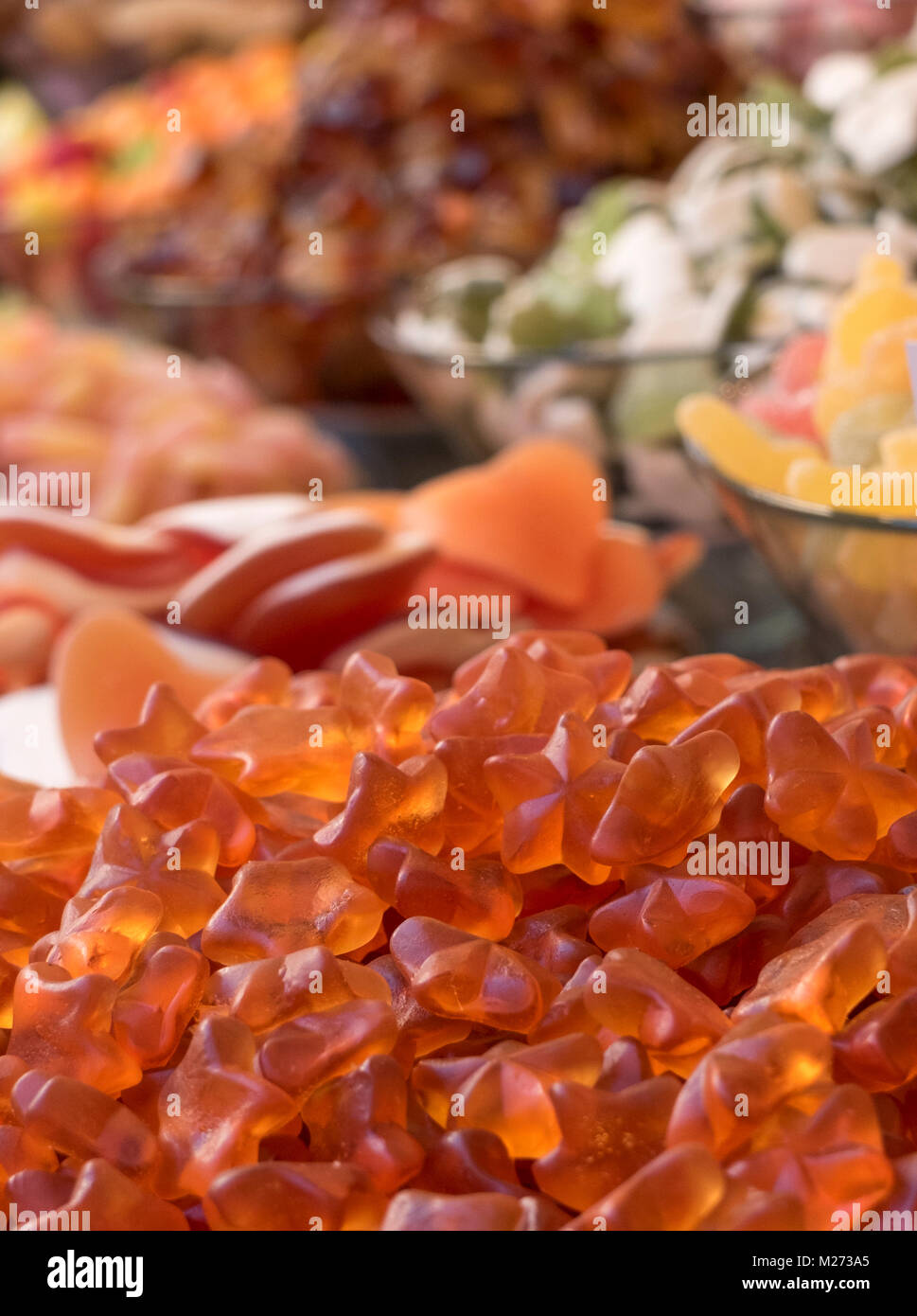 Close up of soft orange fruit candies. The candies are piled up on a ...