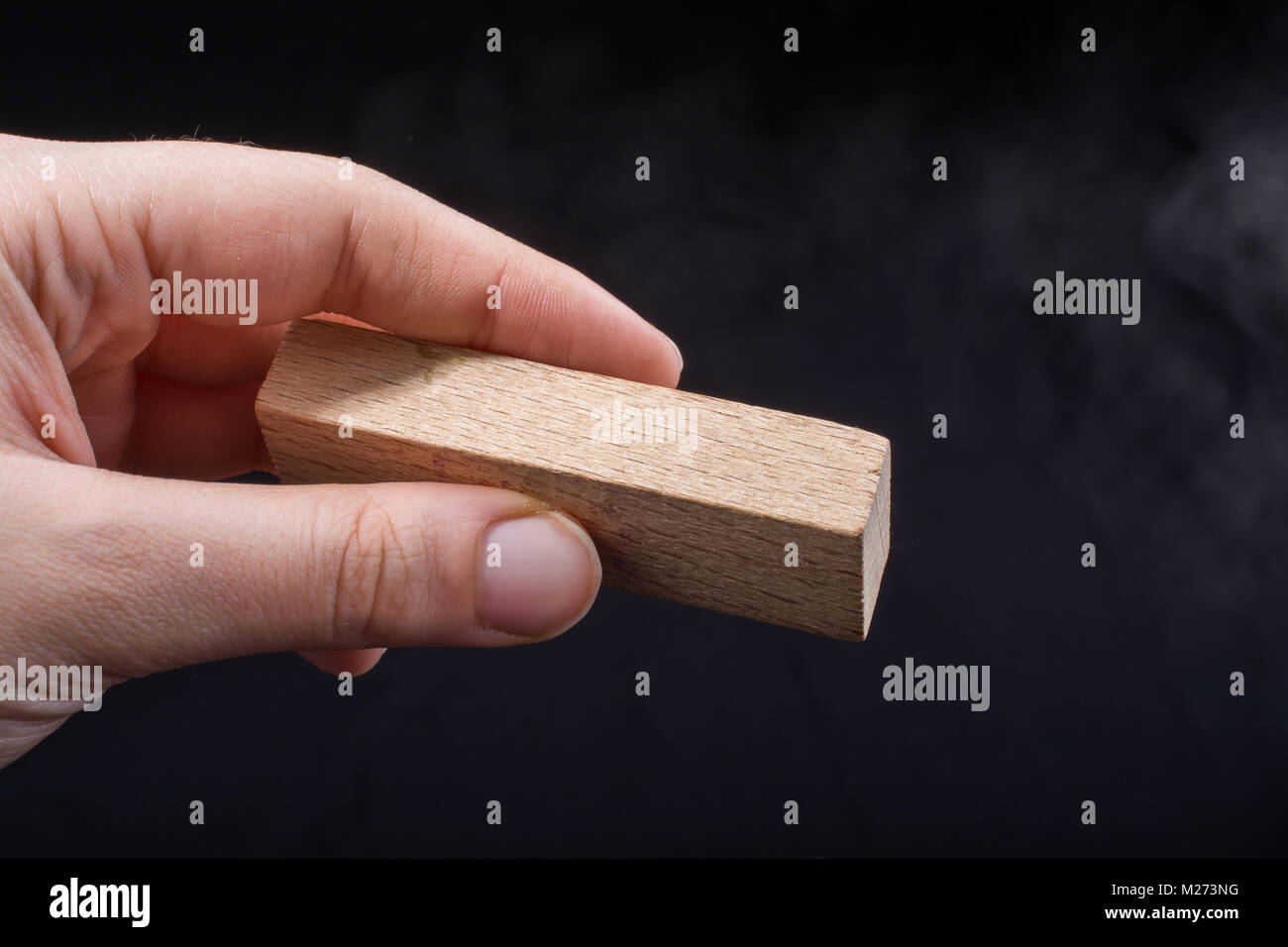 Small piece of cut wood in hand background Stock Photo - Alamy