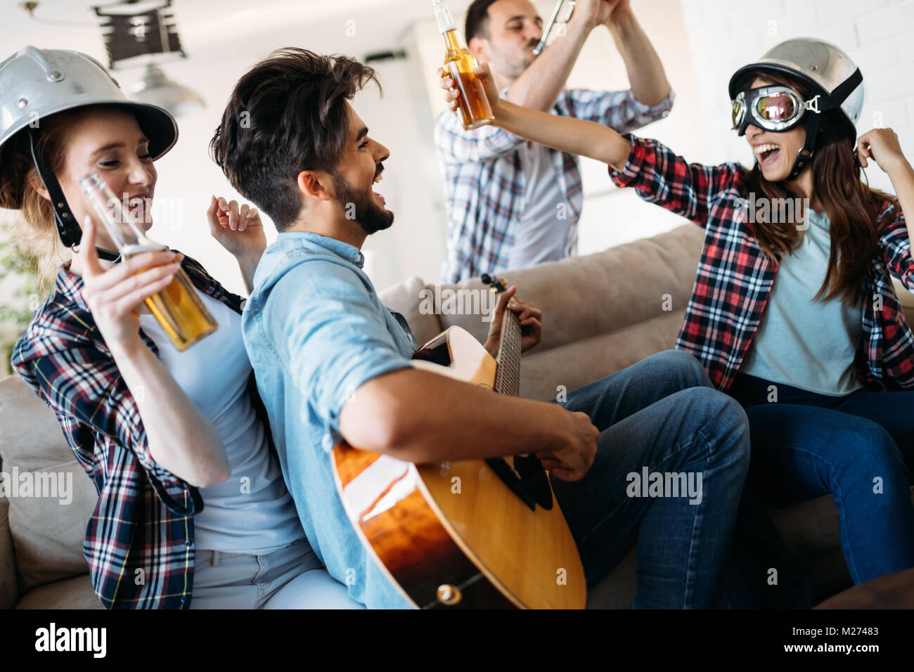 Cheerful friends having party together and playing instruments Stock ...
