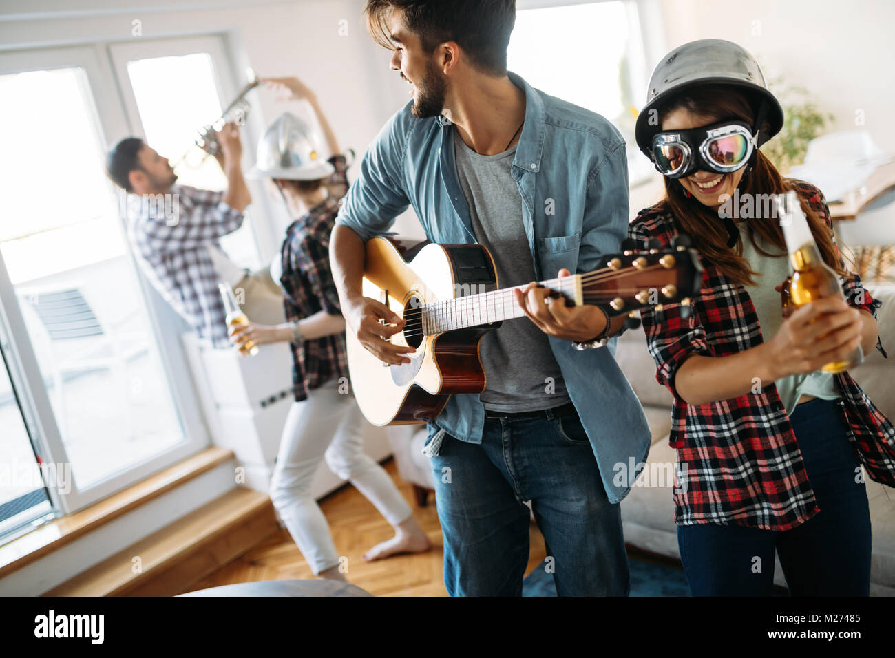 Cheerful friends having party together and playing instruments Stock ...