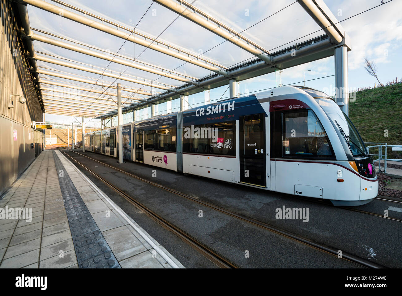 View of tram at platforms at modern Edinburgh Gateway railway and tram ...