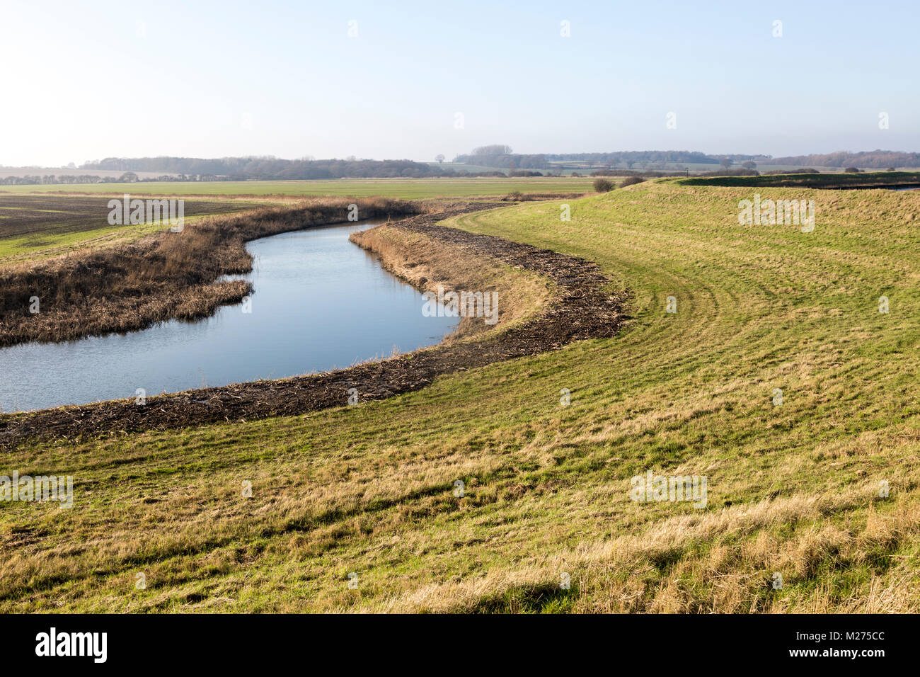 Drainage channel lowland fields inland from flood defence dyke wall ...