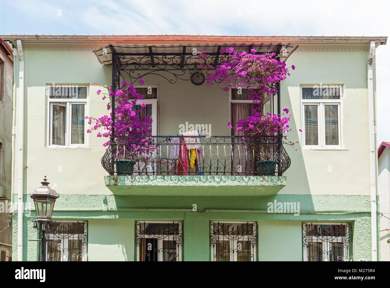 The balcony is decorated with purple flowers Stock Photo - Alamy