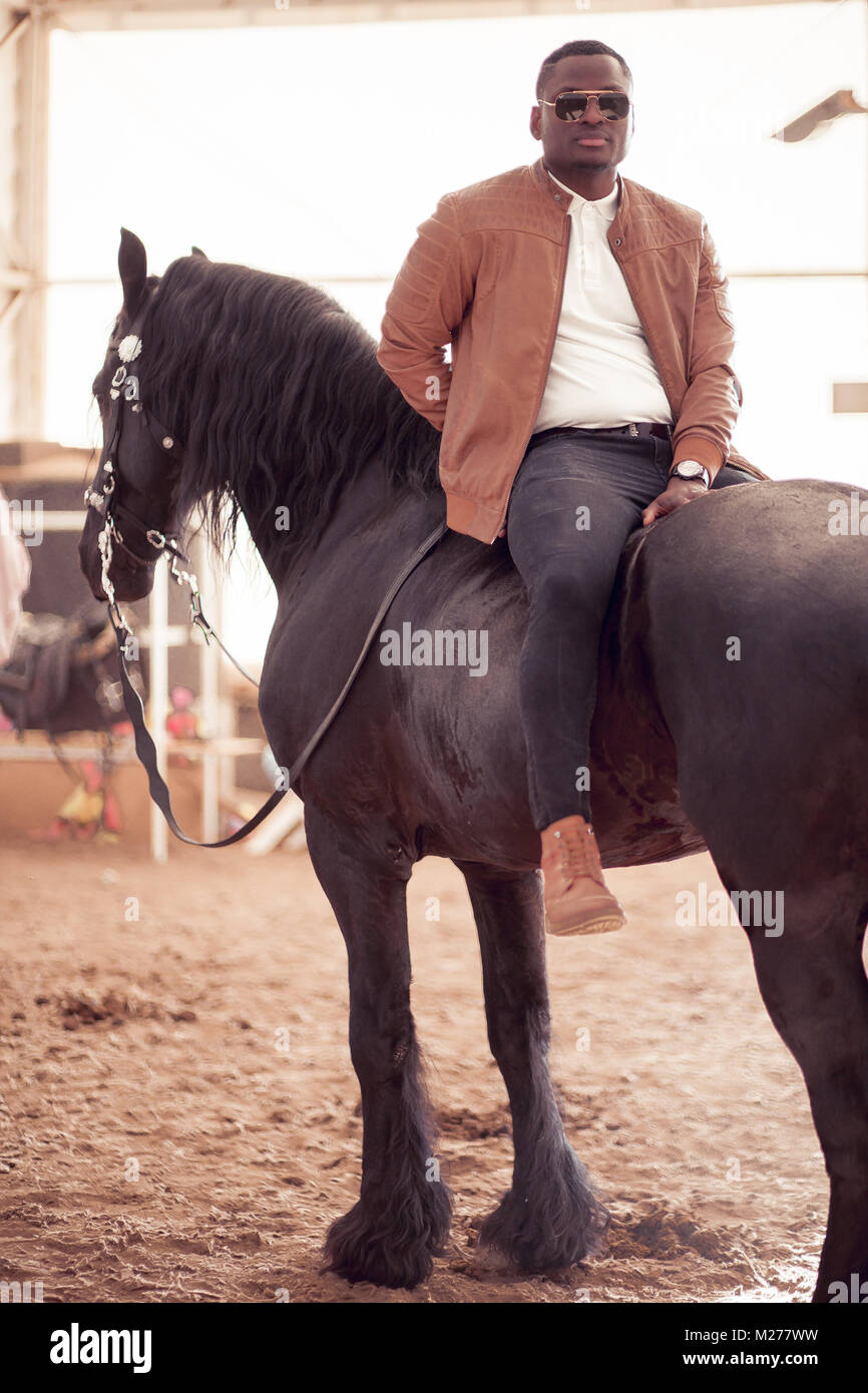 man riding brown horse on countryside Stock Photo - Alamy
