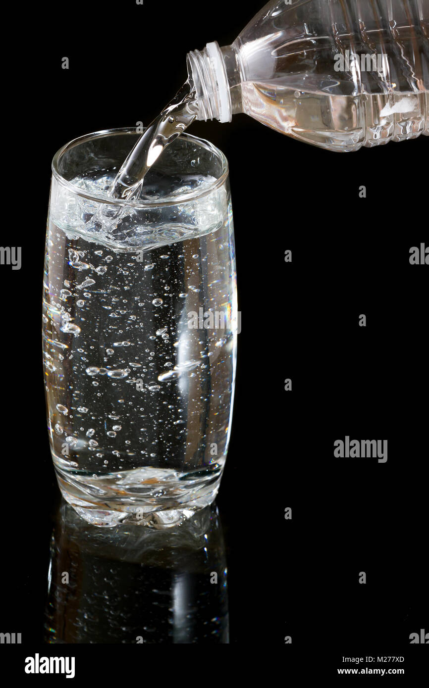 Pouring fresh cold water into the glass from plastic bottle Stock Photo ...