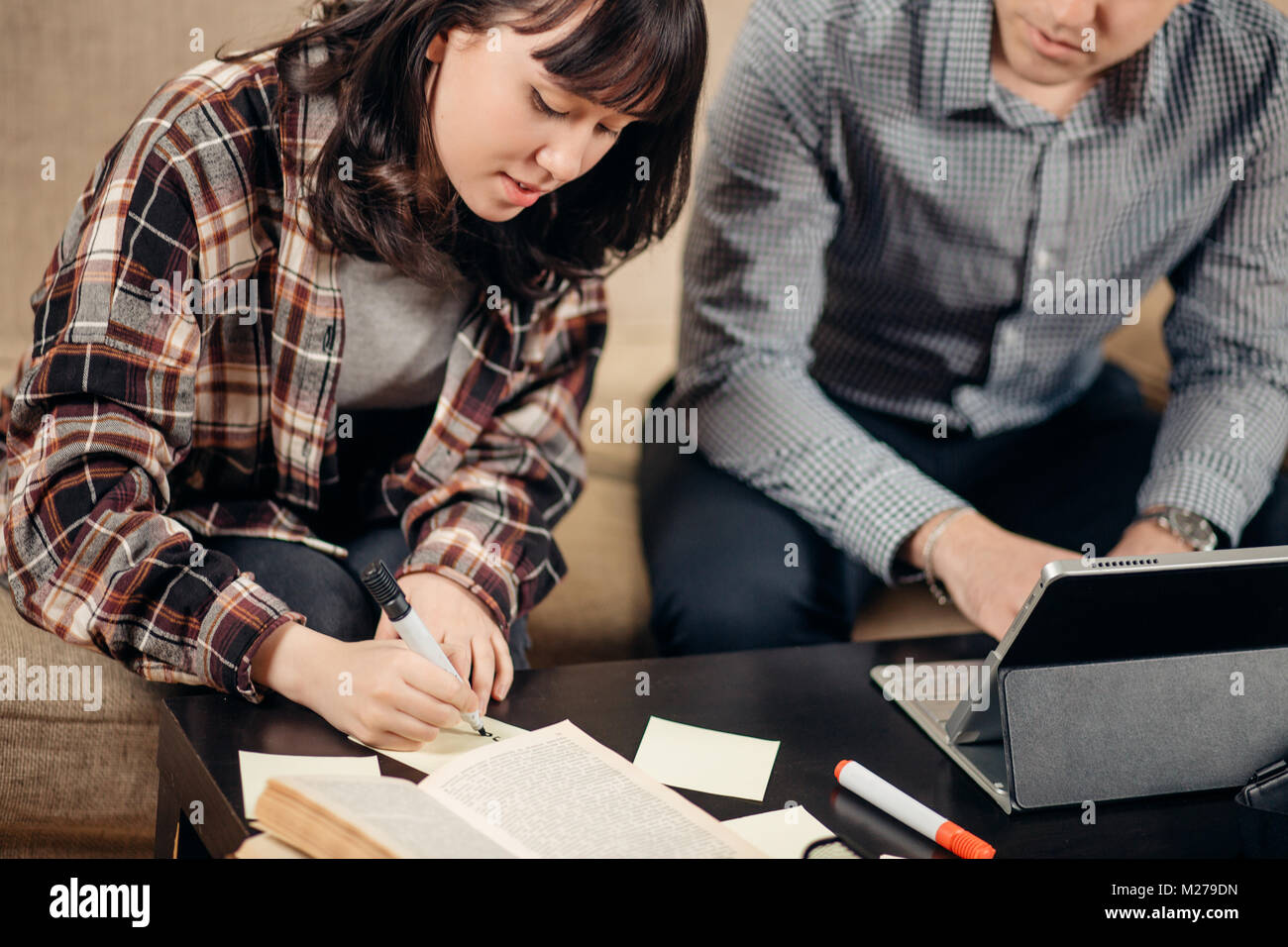 two students working on a project on laptop, the atmosphere is cozy and ...