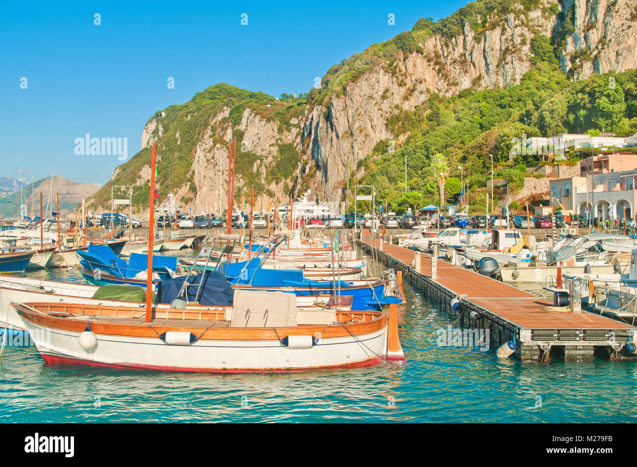 boats in Capri marina with mountains at background at sunset, Italy ...