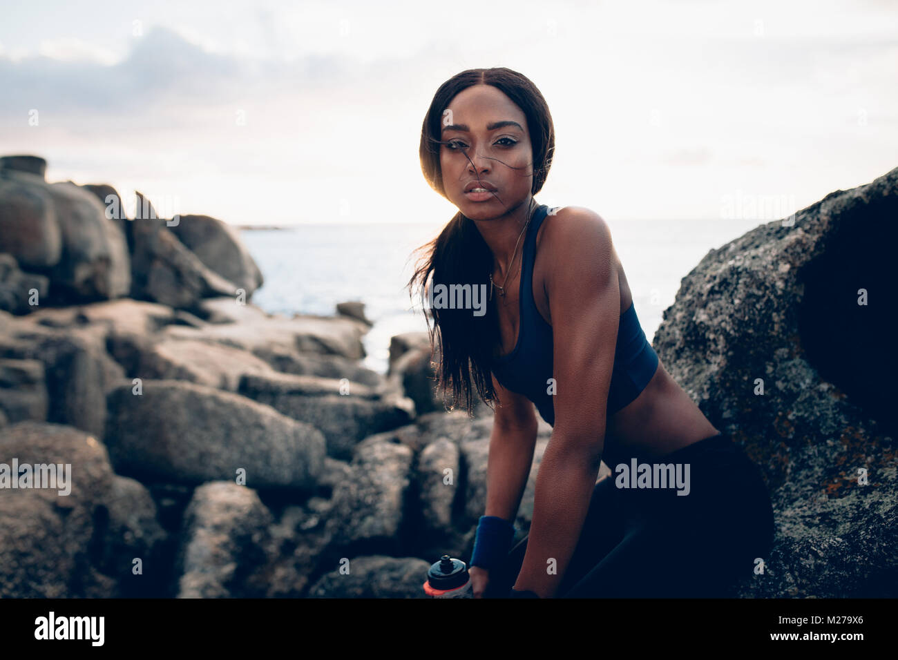 Portrait of fit african woman relaxing after workout outdoors. fitness ...