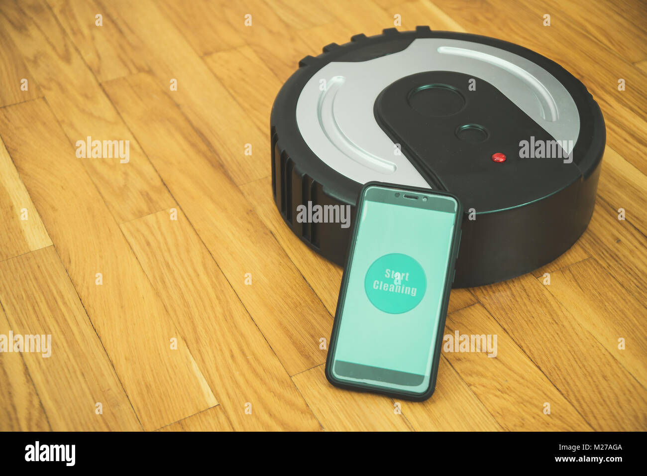 Phone with mobile app to control robotic vacuum cleaner Stock Photo - Alamy