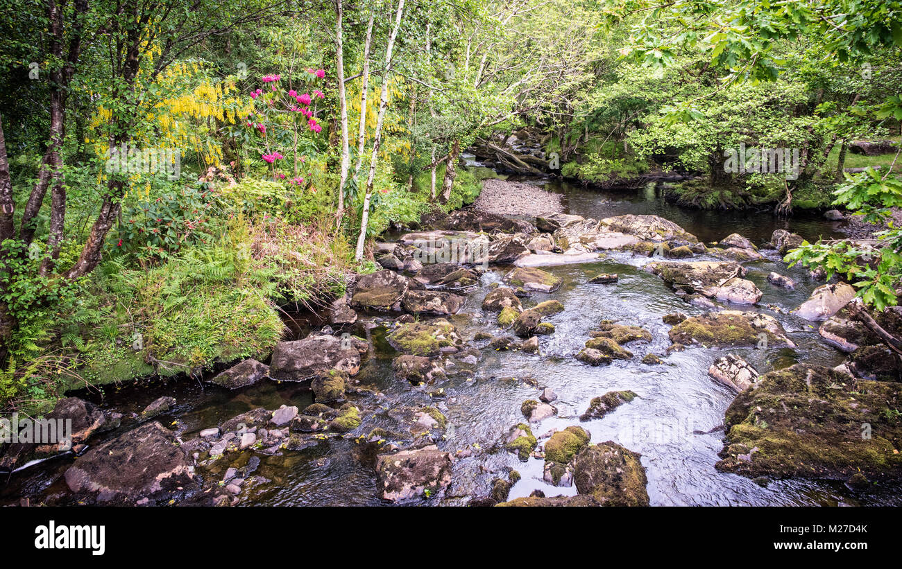 River flowing around rocks in pretty valley Stock Photo - Alamy