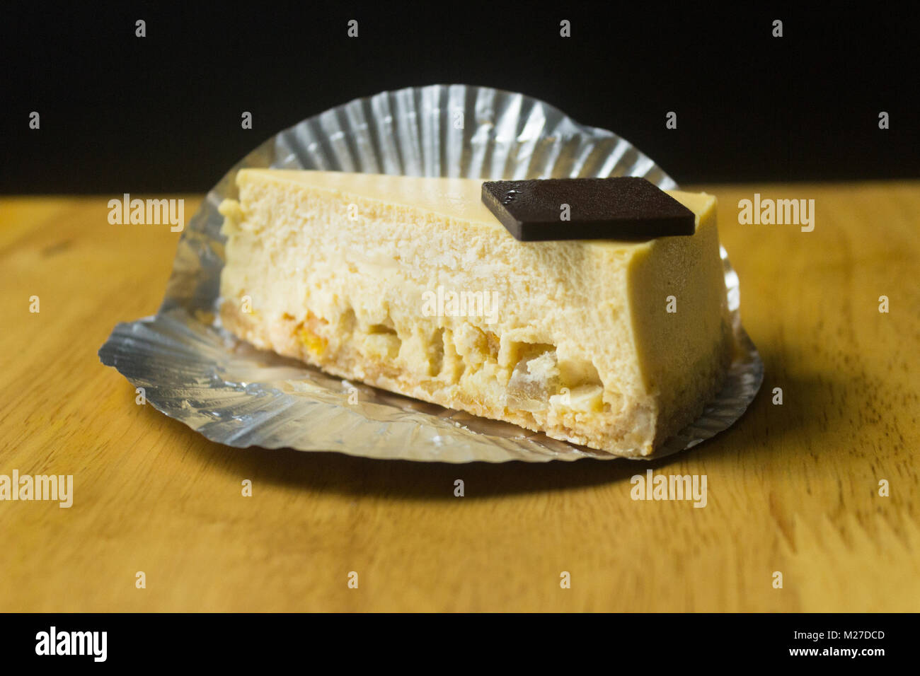 Piece of cheesecake on wood table and dark background Stock Photo - Alamy