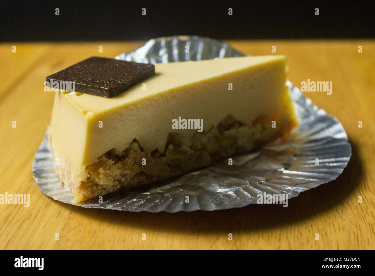 Piece of cheesecake on wood table and dark background Stock Photo - Alamy