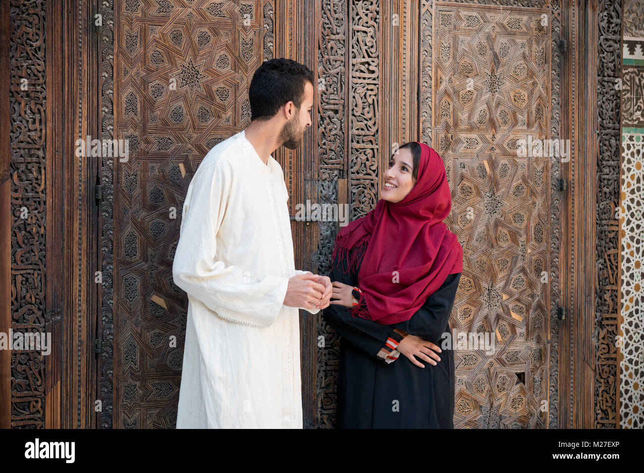 Muslim couple in relationship talking and smiling in traditional ...