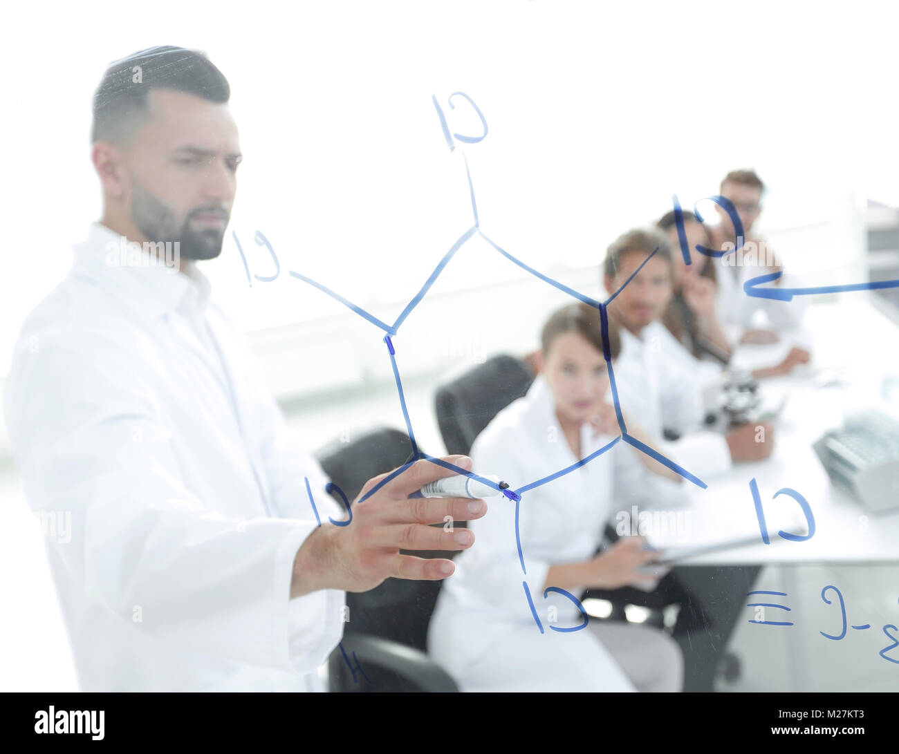 from behind the glass. a scientist standing near the blackboard in the ...