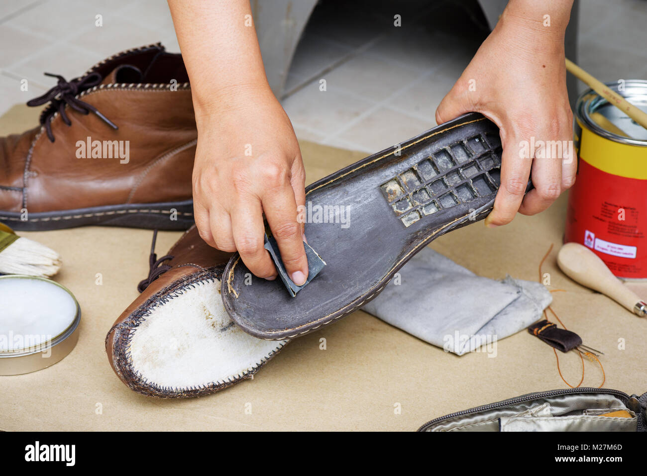 sanding the shoe before apply adhesive, shoe repair Stock Photo - Alamy