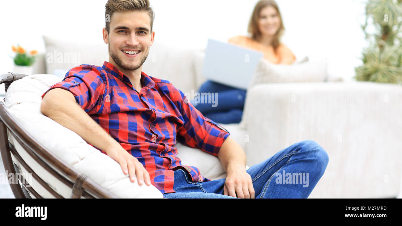 smiling young male sitting in a big chair Stock Photo - Alamy