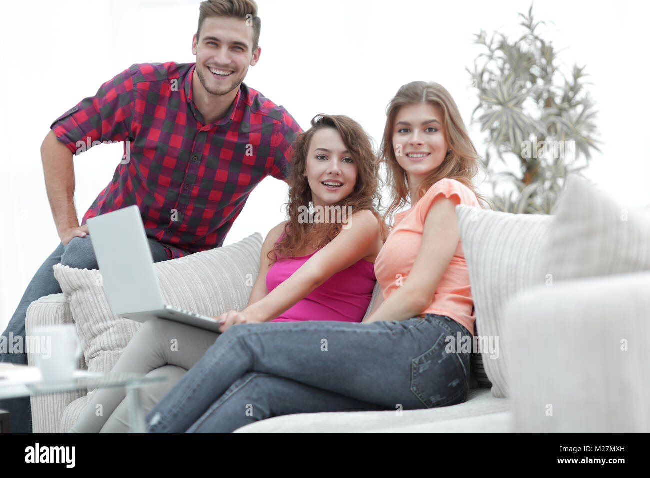 group of young people sitting on the couch in the living room Stock ...