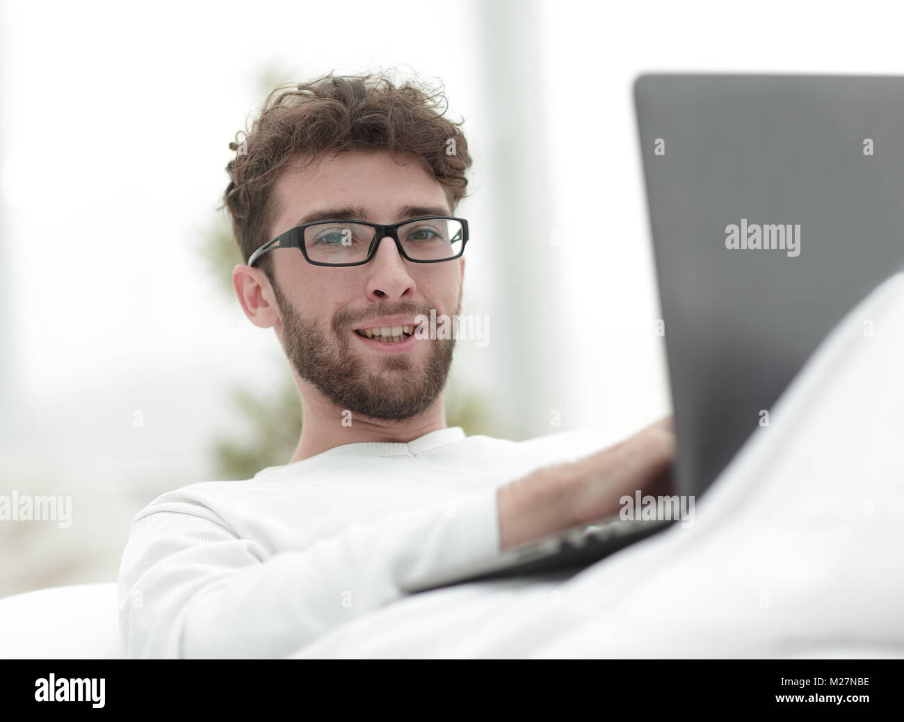 smiling man using laptop lying on bed Stock Photo - Alamy