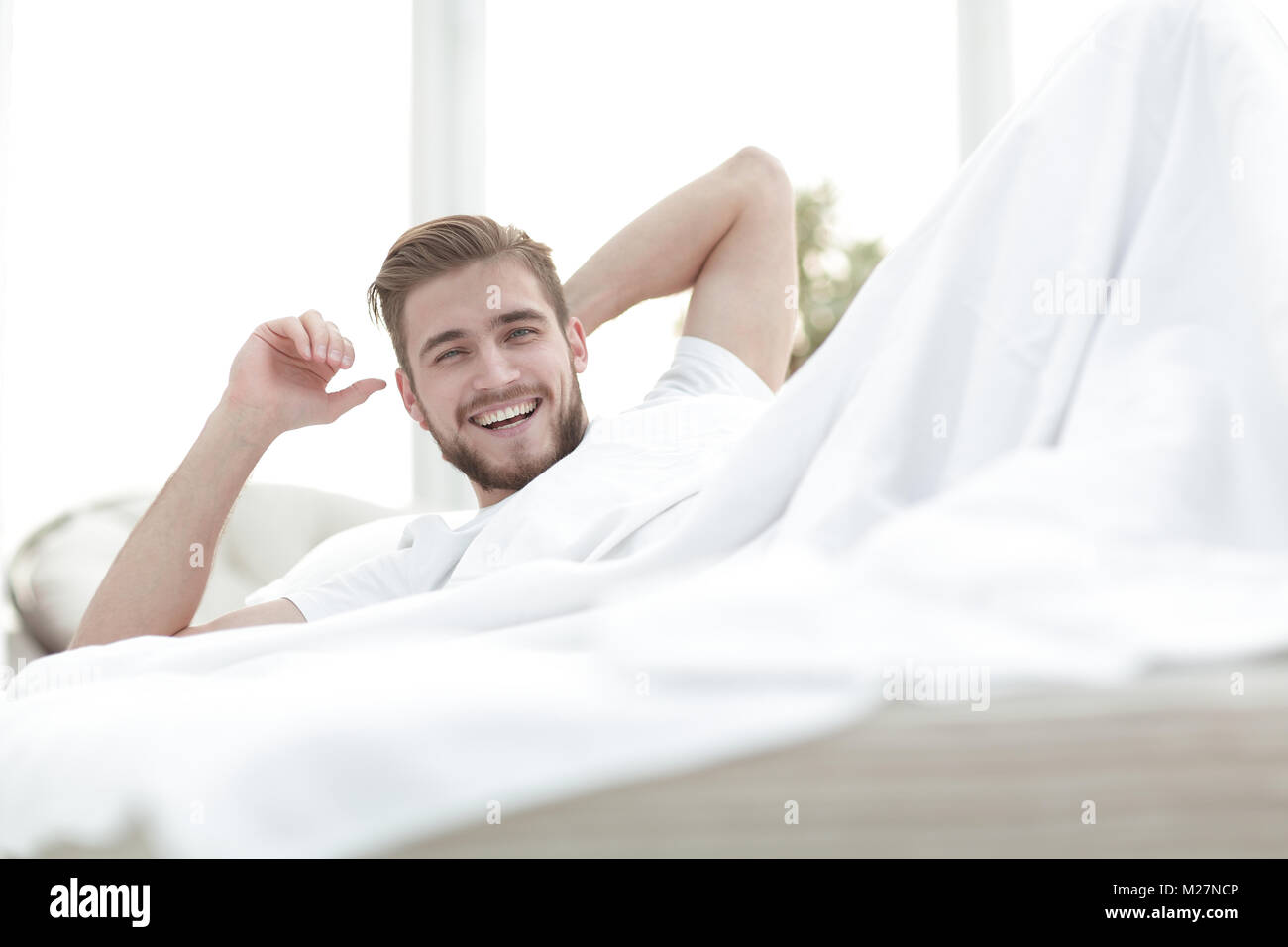 closeup.smiling man lying on the couch Stock Photo - Alamy