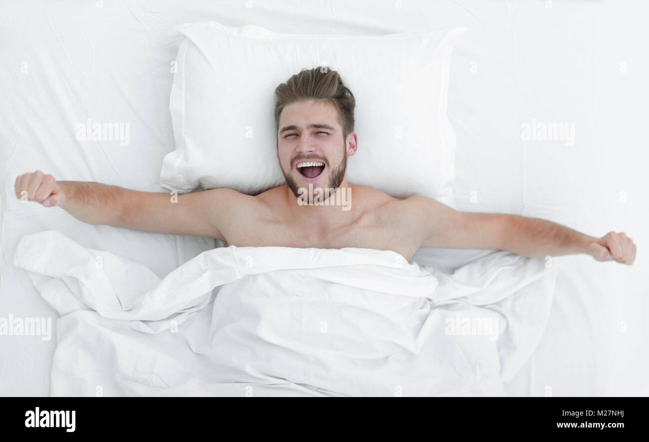 top view. happy man waking up in a comfortable bed Stock Photo - Alamy