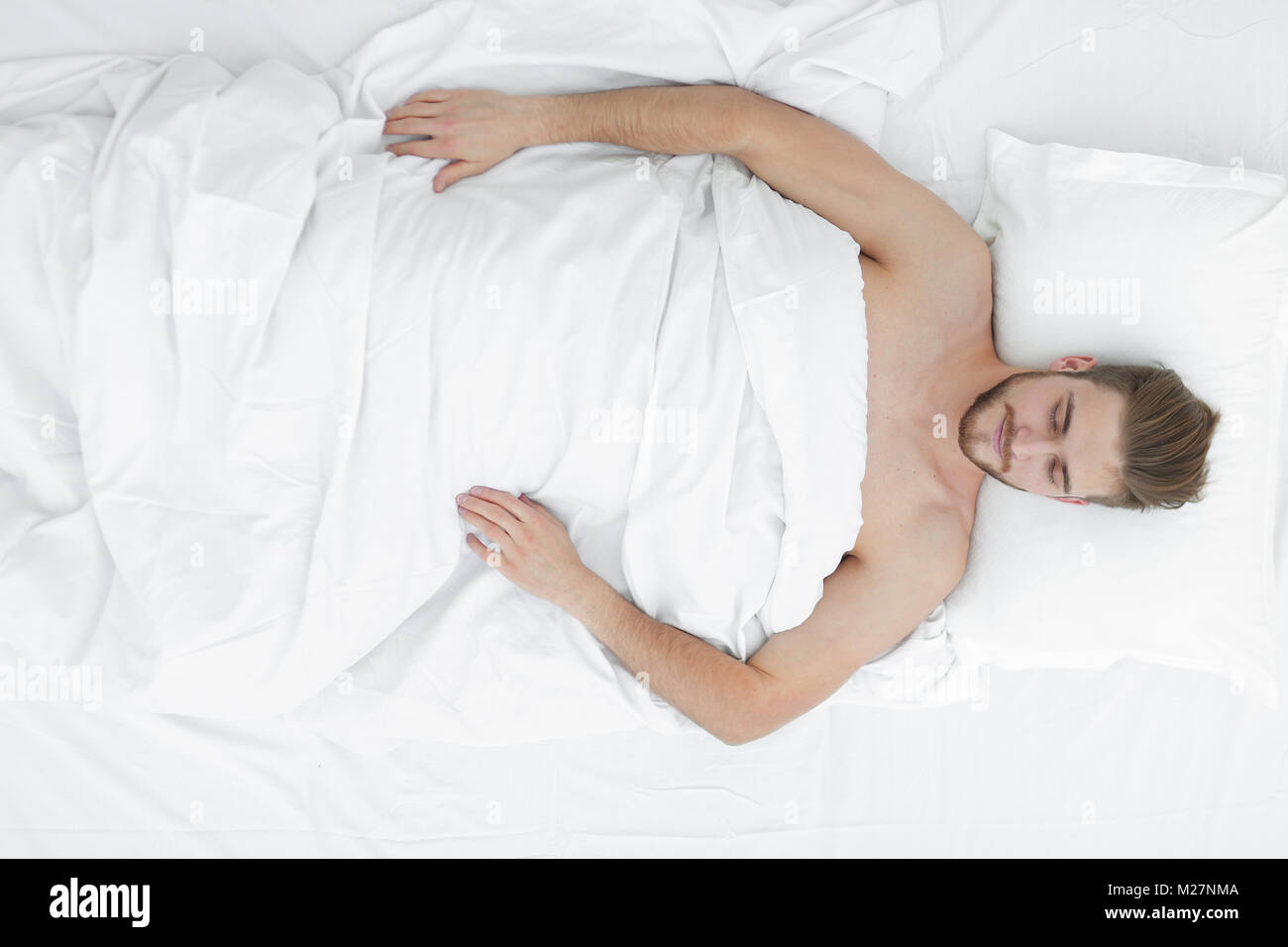 Young man relaxation on the bed top view Stock Photo - Alamy