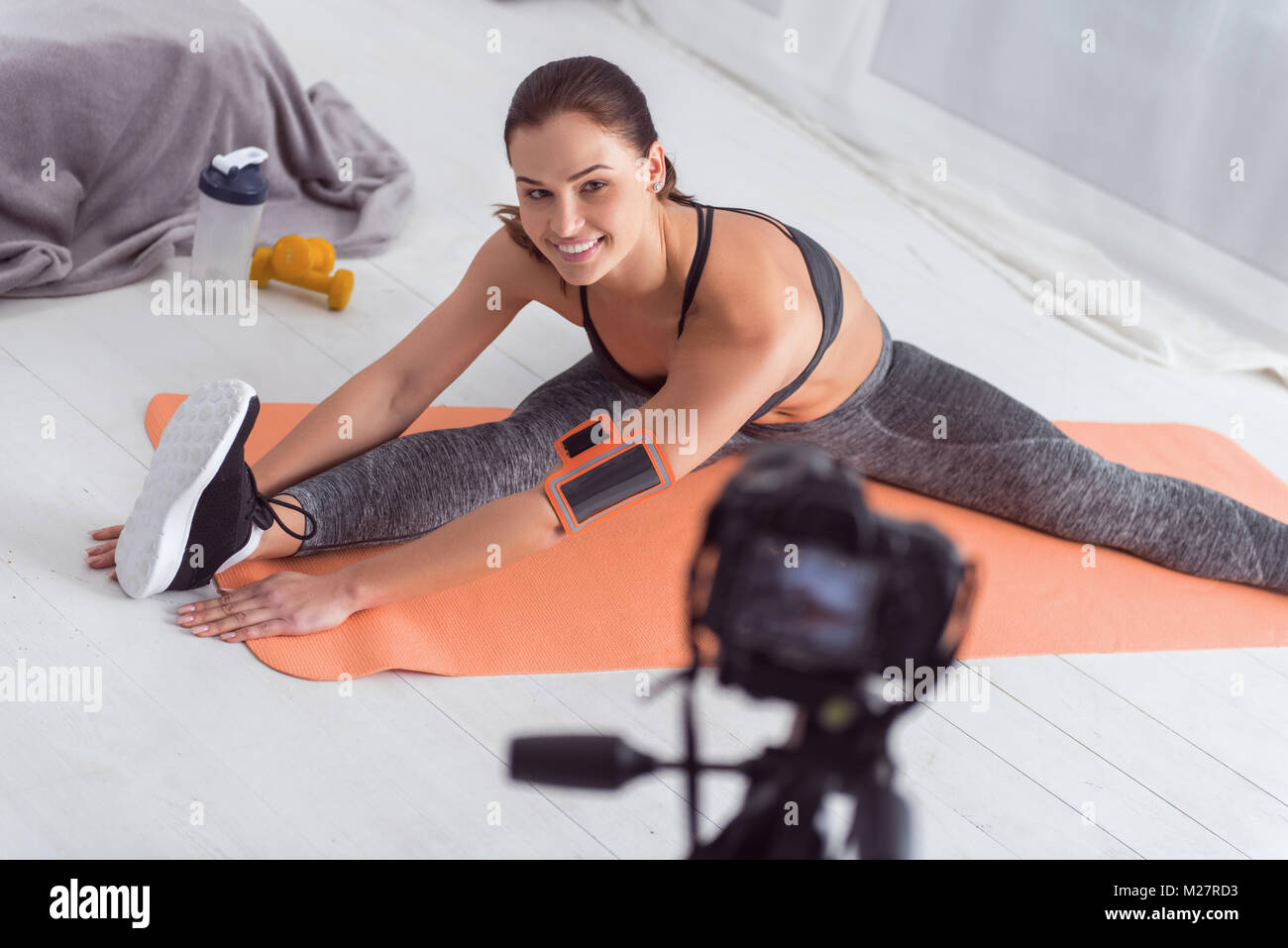 Cheerful young woman stretching for camera Stock Photo - Alamy