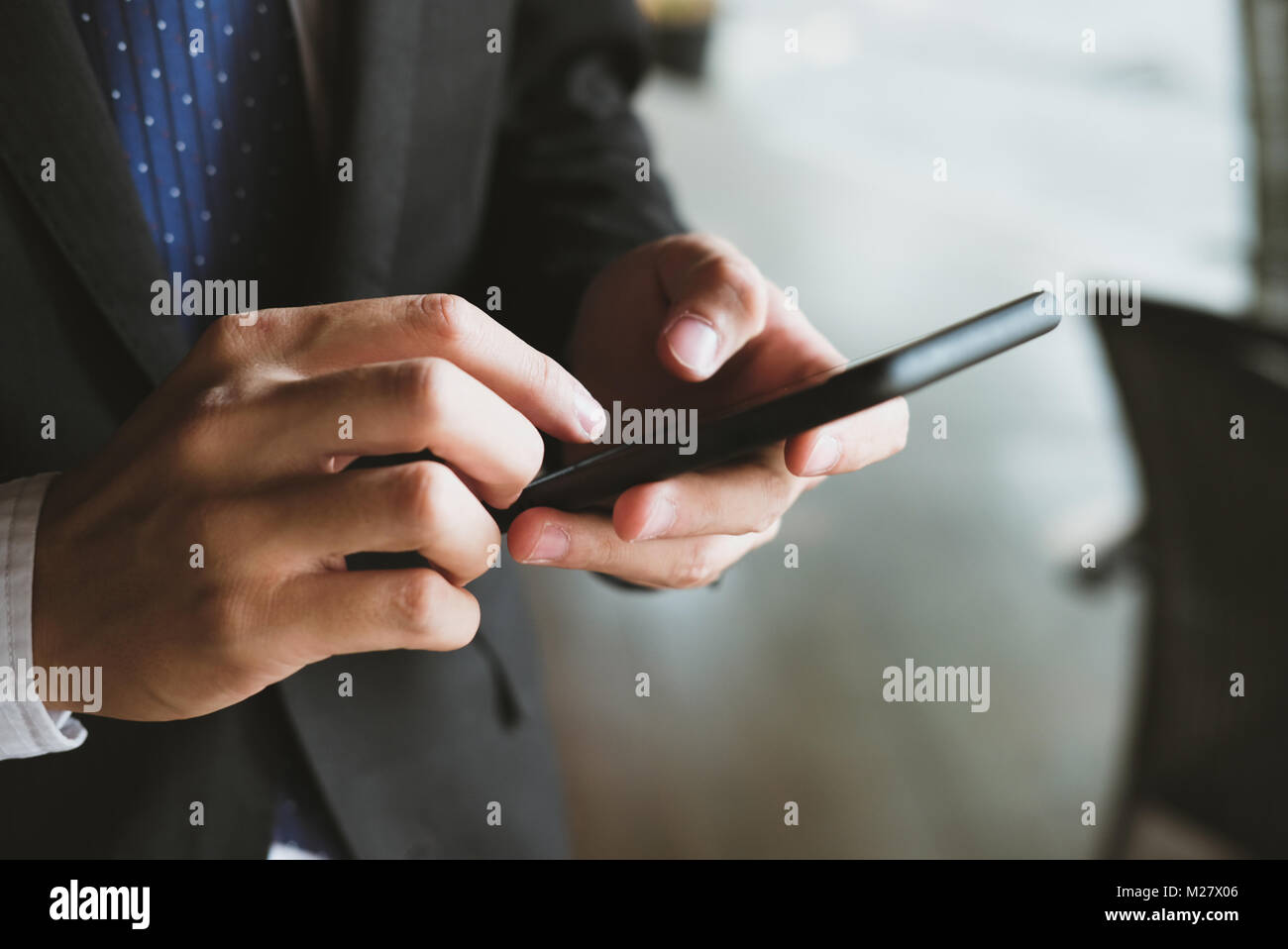 young businessman holding smartphone & using app. man texting message ...