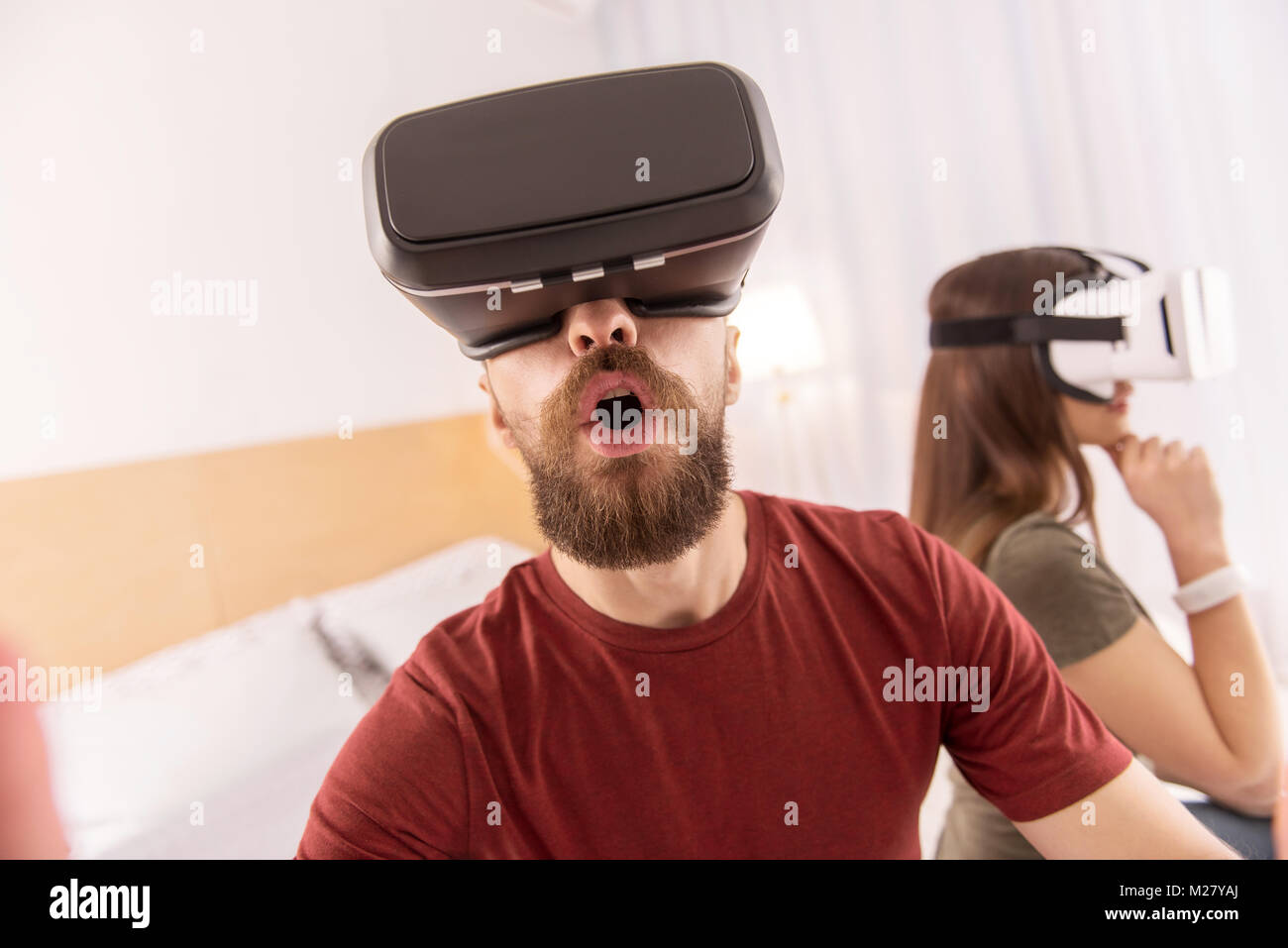 Amazed handsome man watching through VR glasses Stock Photo - Alamy
