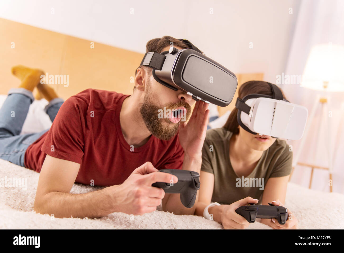 Charming sincere couple playing in VR headsets Stock Photo - Alamy