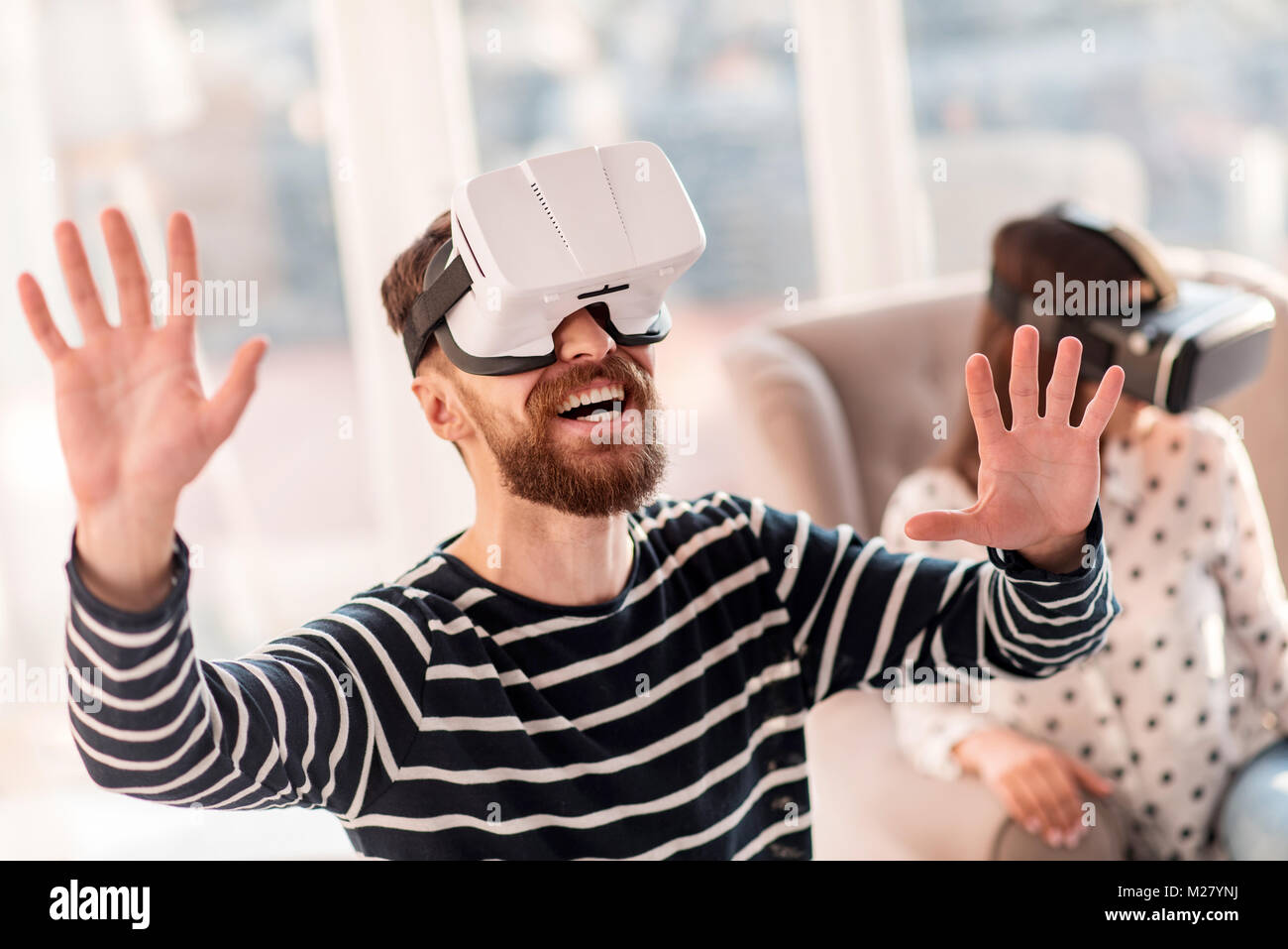 Energetic enthusiastic man catching VR object Stock Photo - Alamy