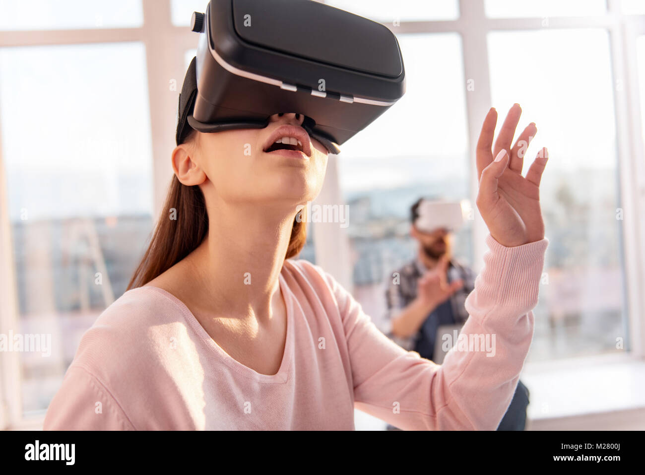 Astonished beautiful woman studying VR universe Stock Photo - Alamy