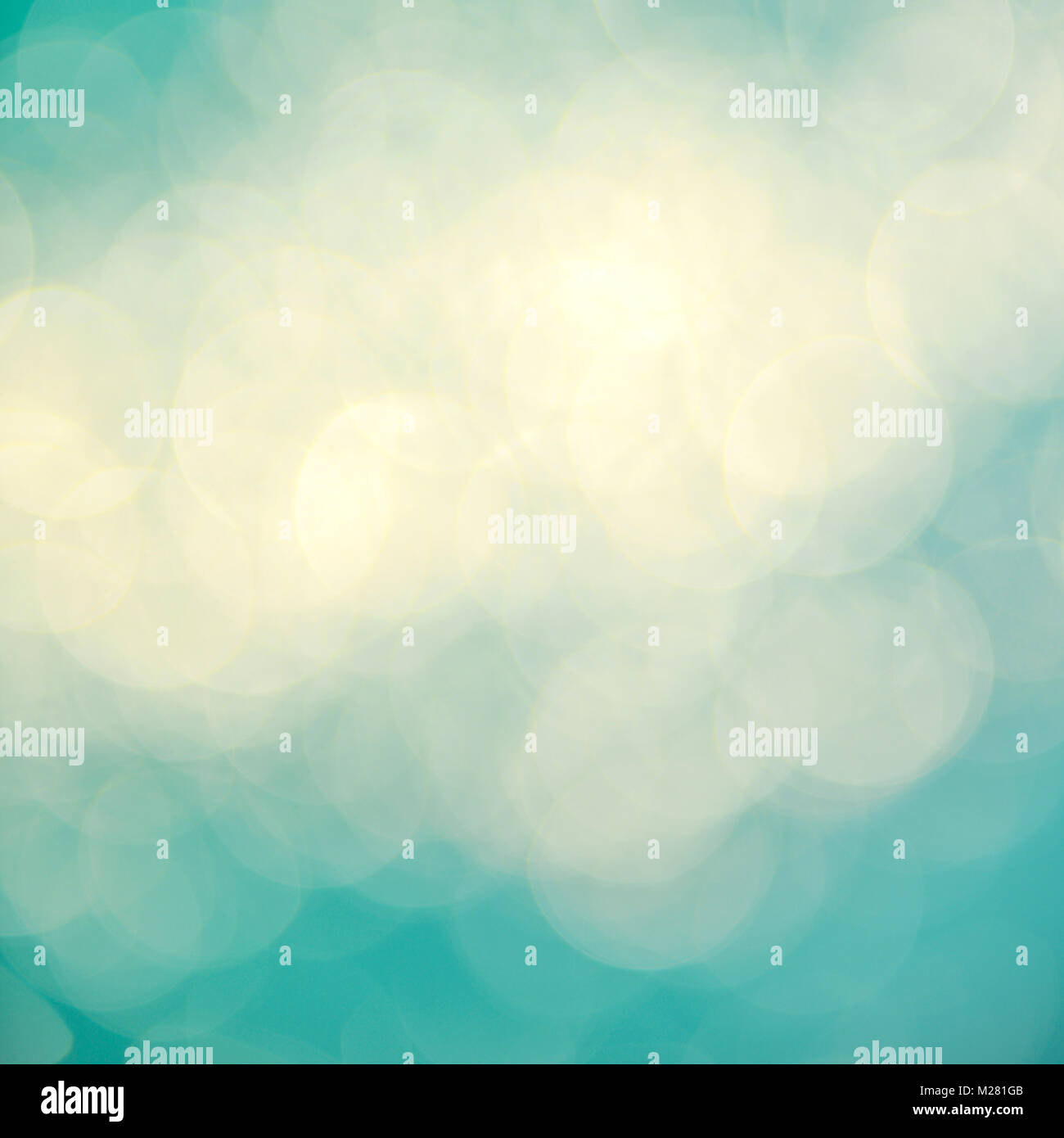Soft focus bokeh light effects over a rippled, blue water background in ...