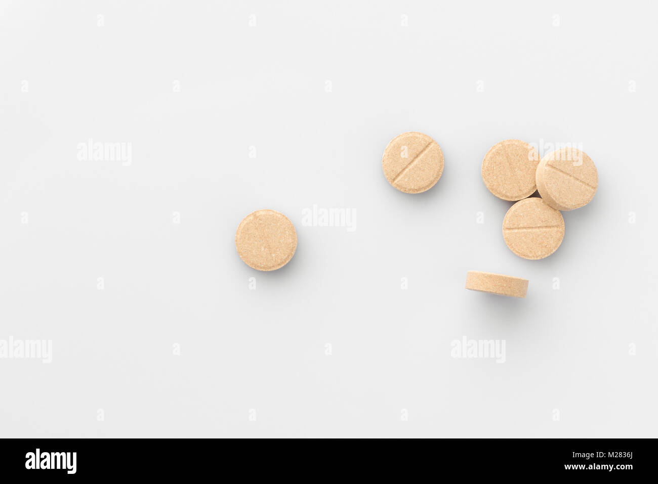 Pile light beige medical tablets on a light background. The view from ...