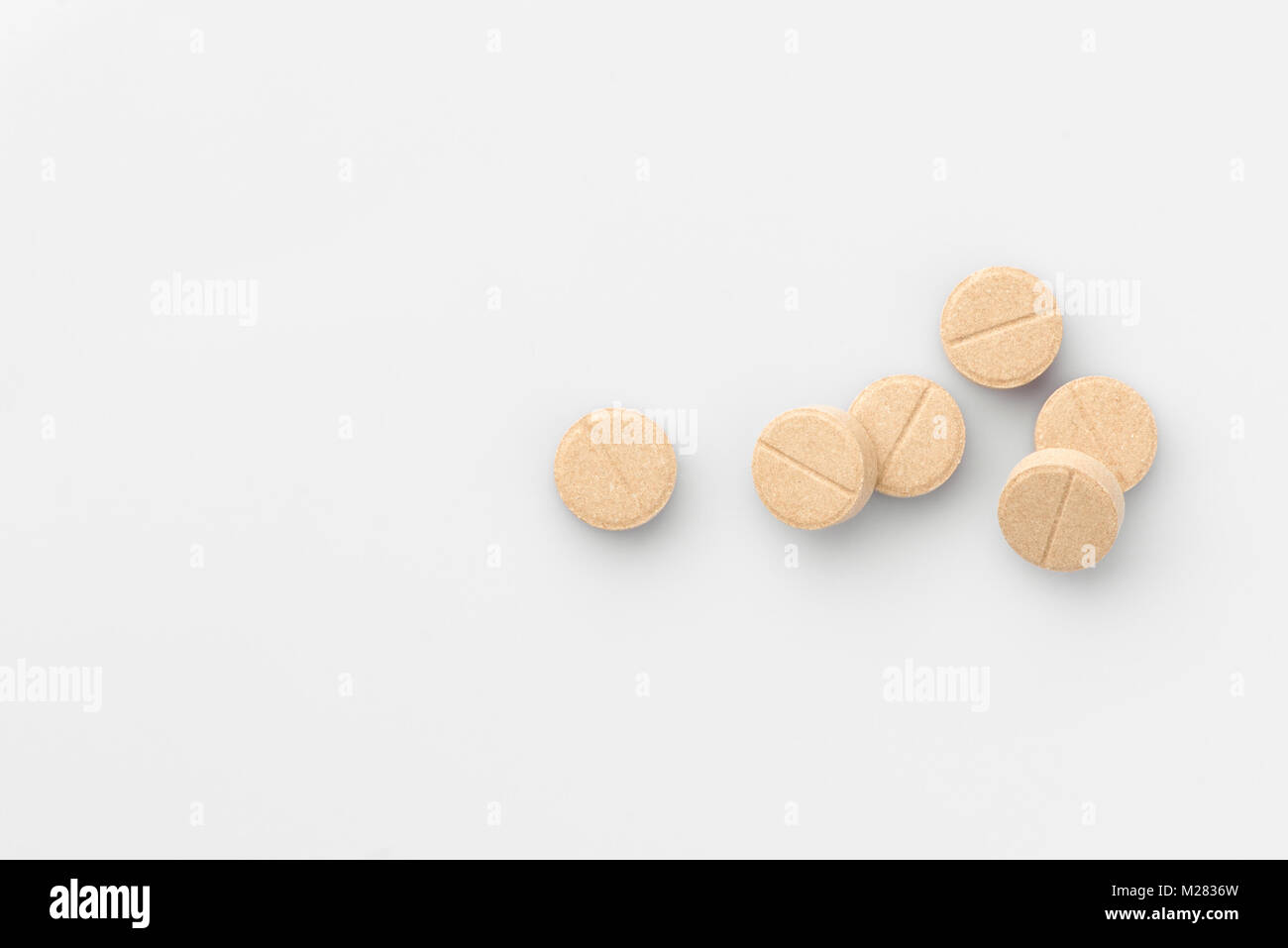 Beige a lot of medical pills on white background. The view from the top ...