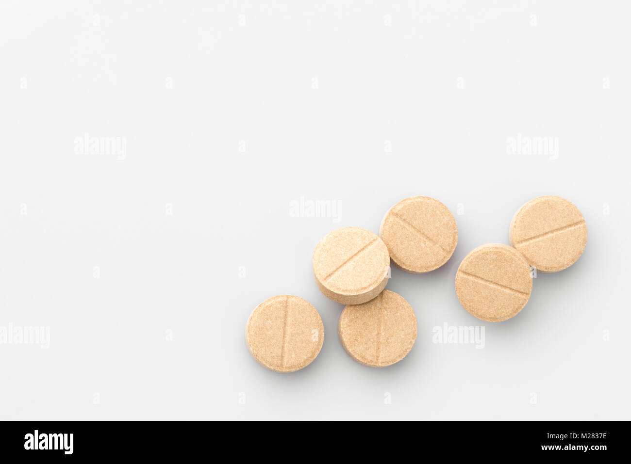 Beige a lot of medical pills on white background. The view from the top ...