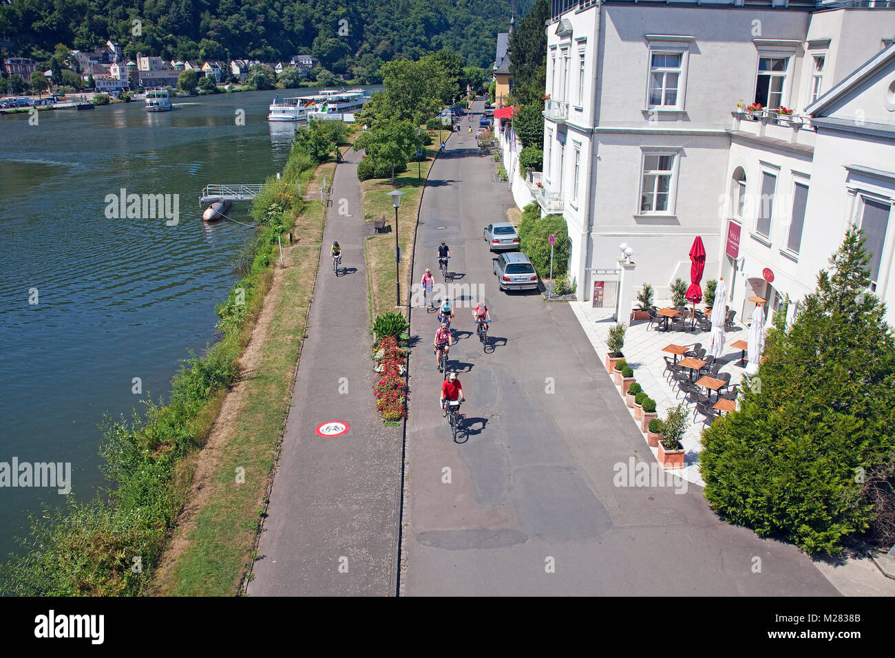 Group of cyclists on promenade at riverside,Traben, Traben-Trarbach ...