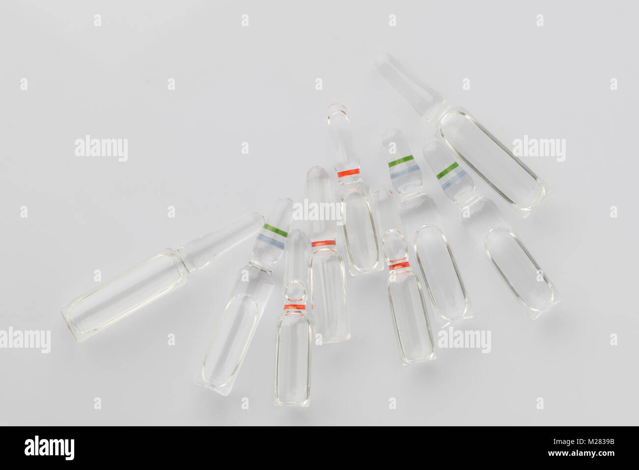Heap of medical ampoules of liquid for injection on a white background ...
