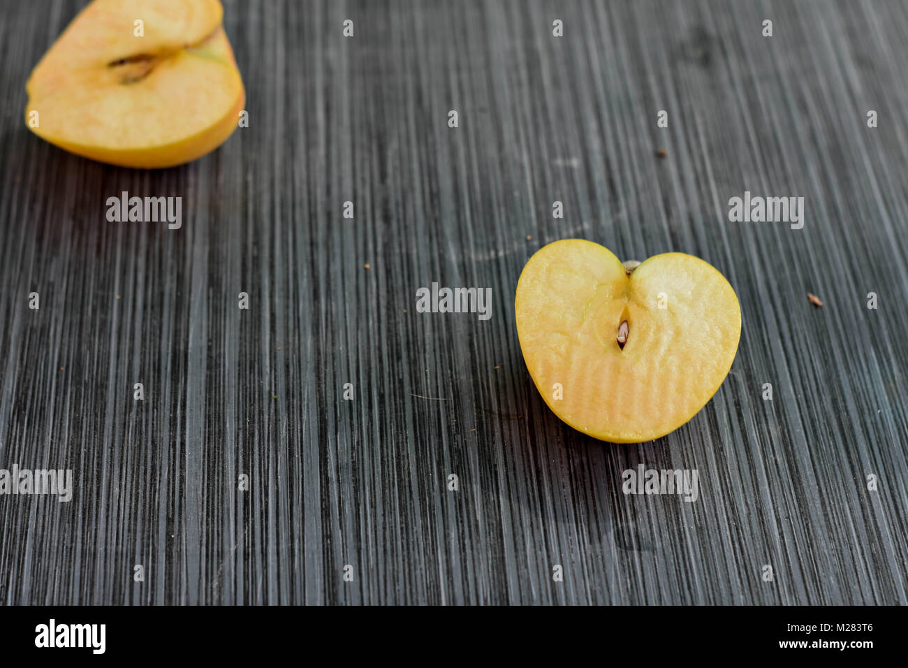 Sliced fresh apple/ heart shape/ on wood background/ closeup still life ...