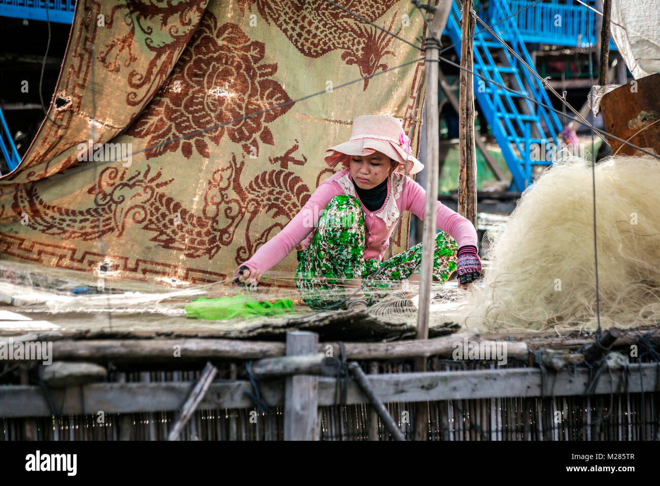 Cambodian woman mending fishing net, Kampong Phluk Floating Village ...