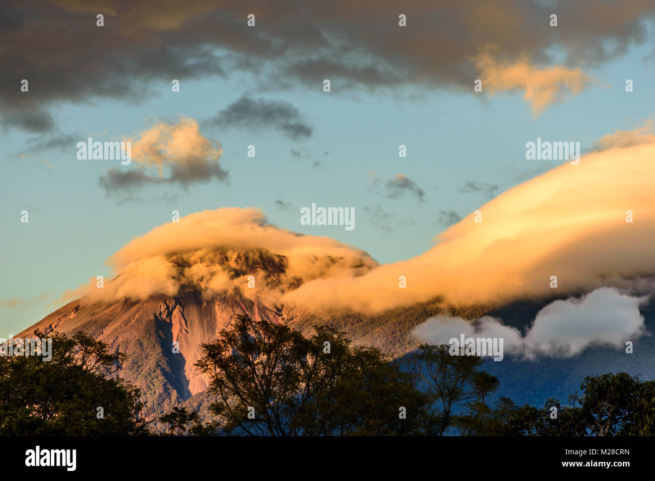 Dawn colors of cloud-shrouded Fuego volcano (left) & Acatenango volcano ...