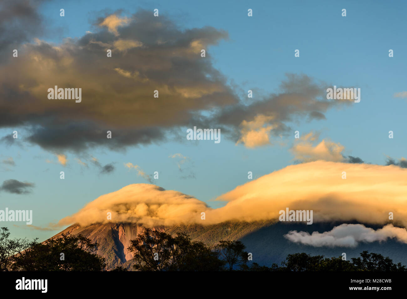 Dawn colors of cloud-shrouded Fuego volcano (left) & Acatenango volcano ...