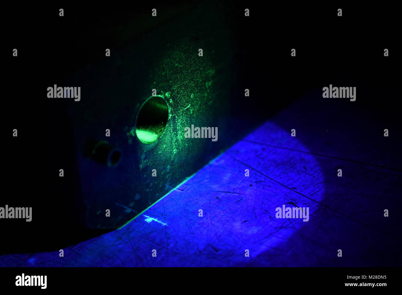 Magnetic particles glow under a blacklight during an inspection ...