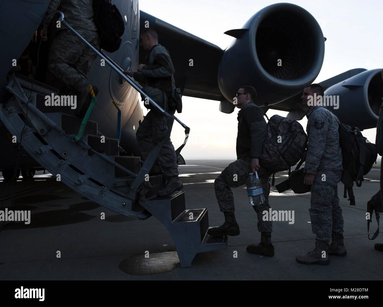 Airmen with the 60th Maintenance Group file onto a bus to take them out ...