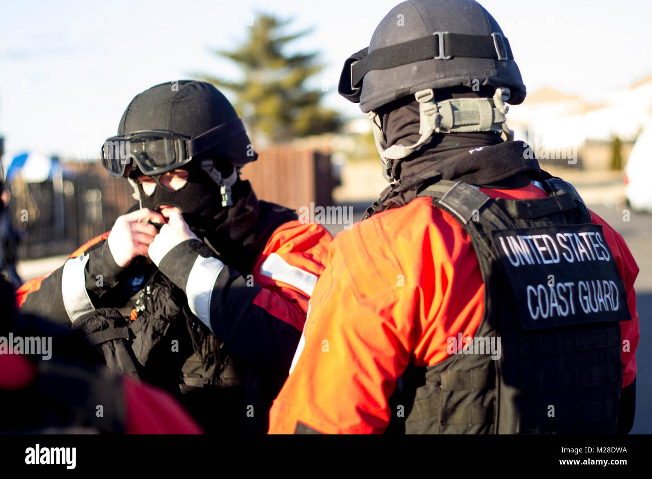 Coast Guard members equip cold weather gear and weapons before getting ...