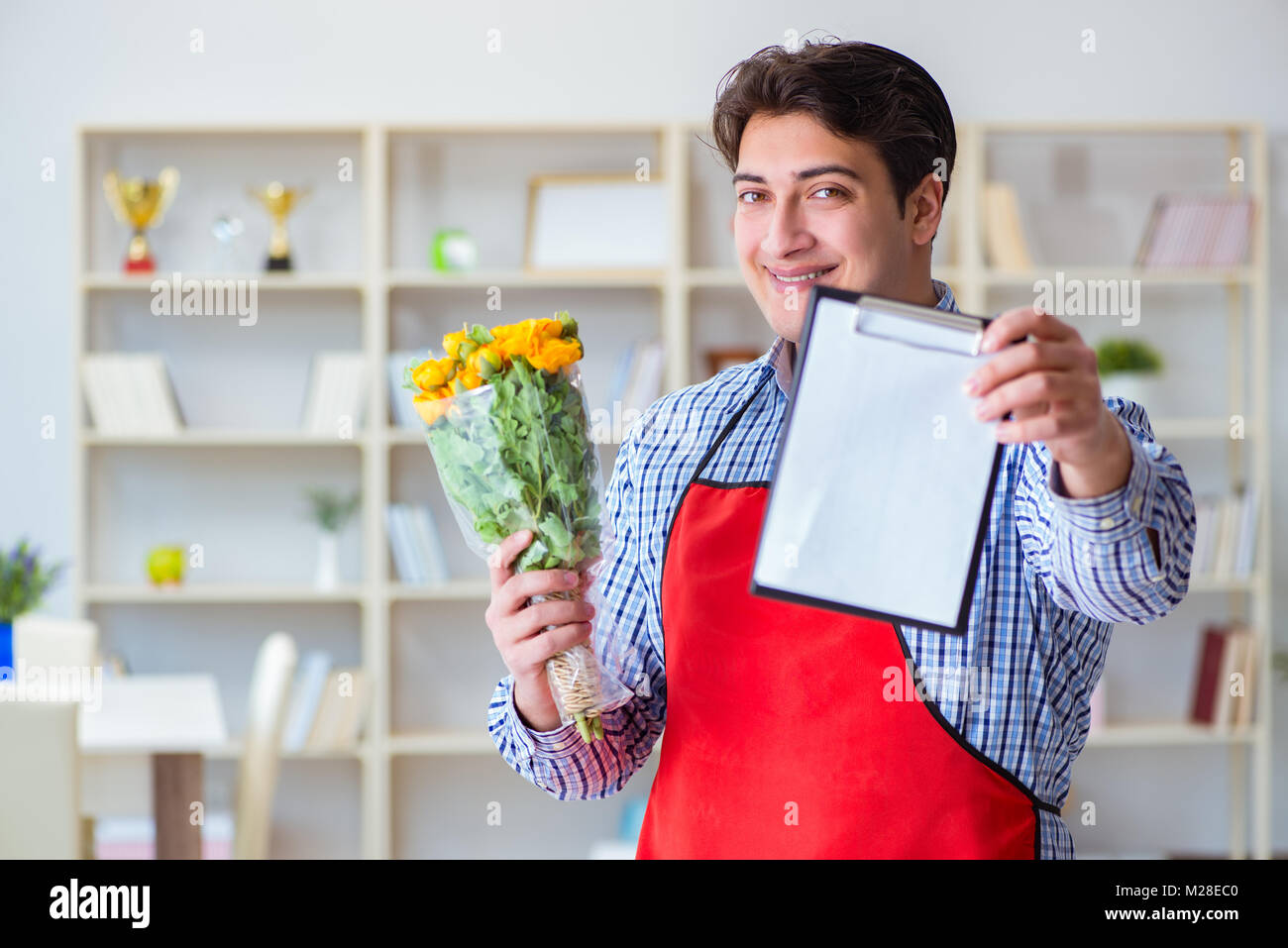 Flower shop assistant offering a bunch of flowers Stock Photo - Alamy
