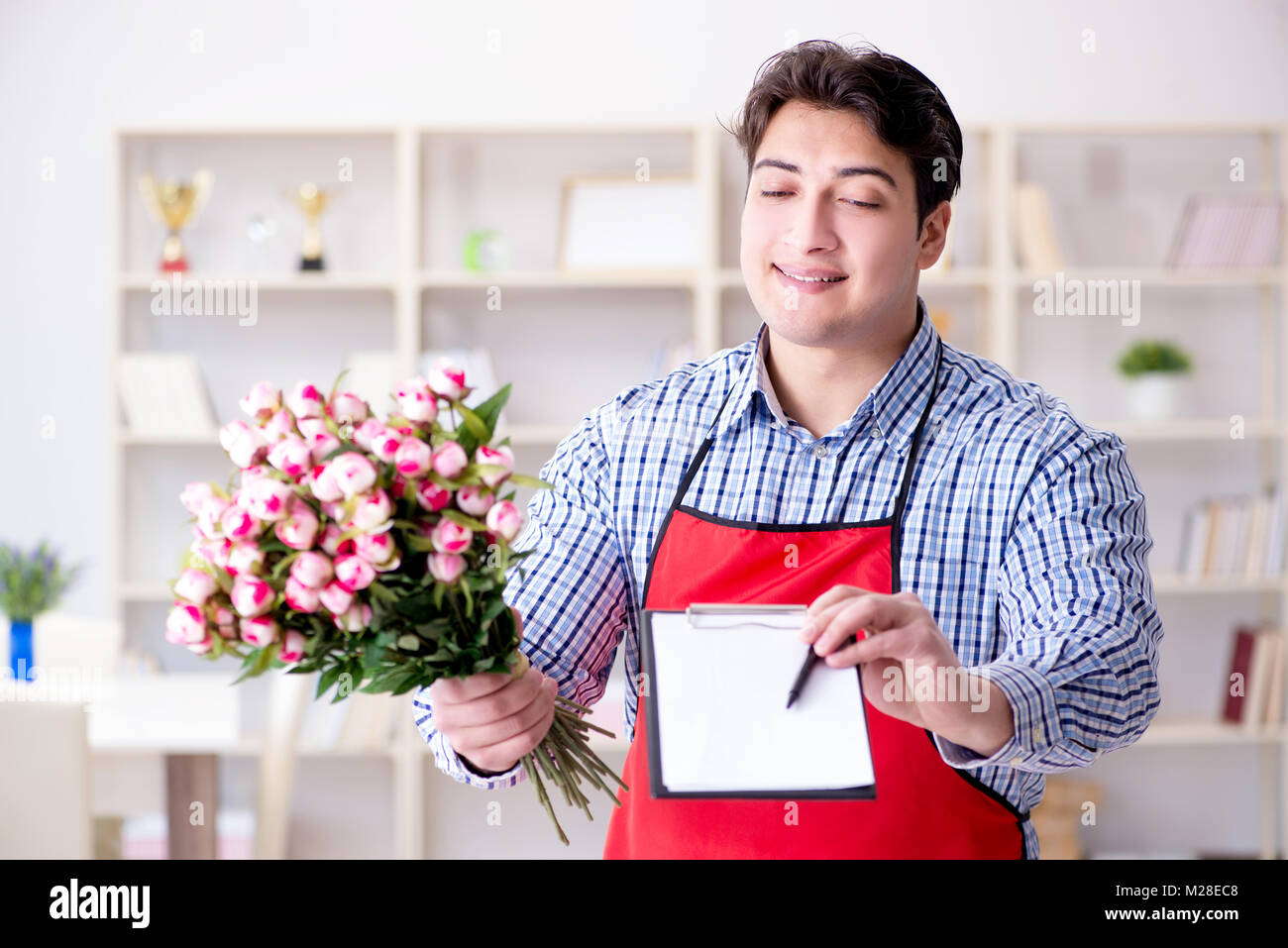 Flower shop assistant offering a bunch of flowers Stock Photo - Alamy